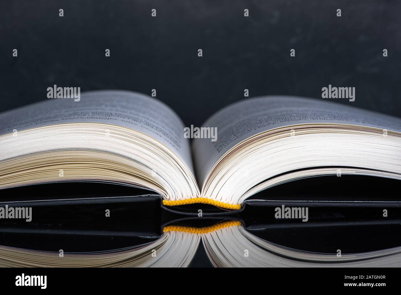 Open book with reflection on table closeup Stock Photo - Alamy