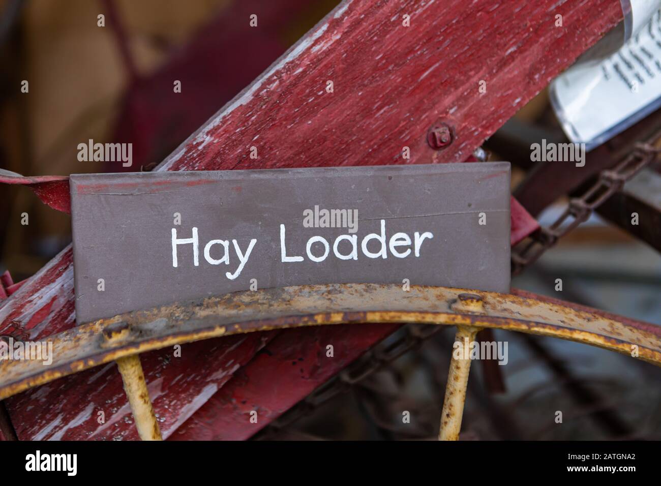 A signboard hanged on the hay loader wheel. Close-up view of antique ...