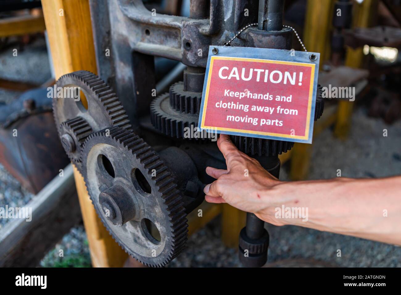 An antique industrial engine with a signboard - caution, keep hands and ...