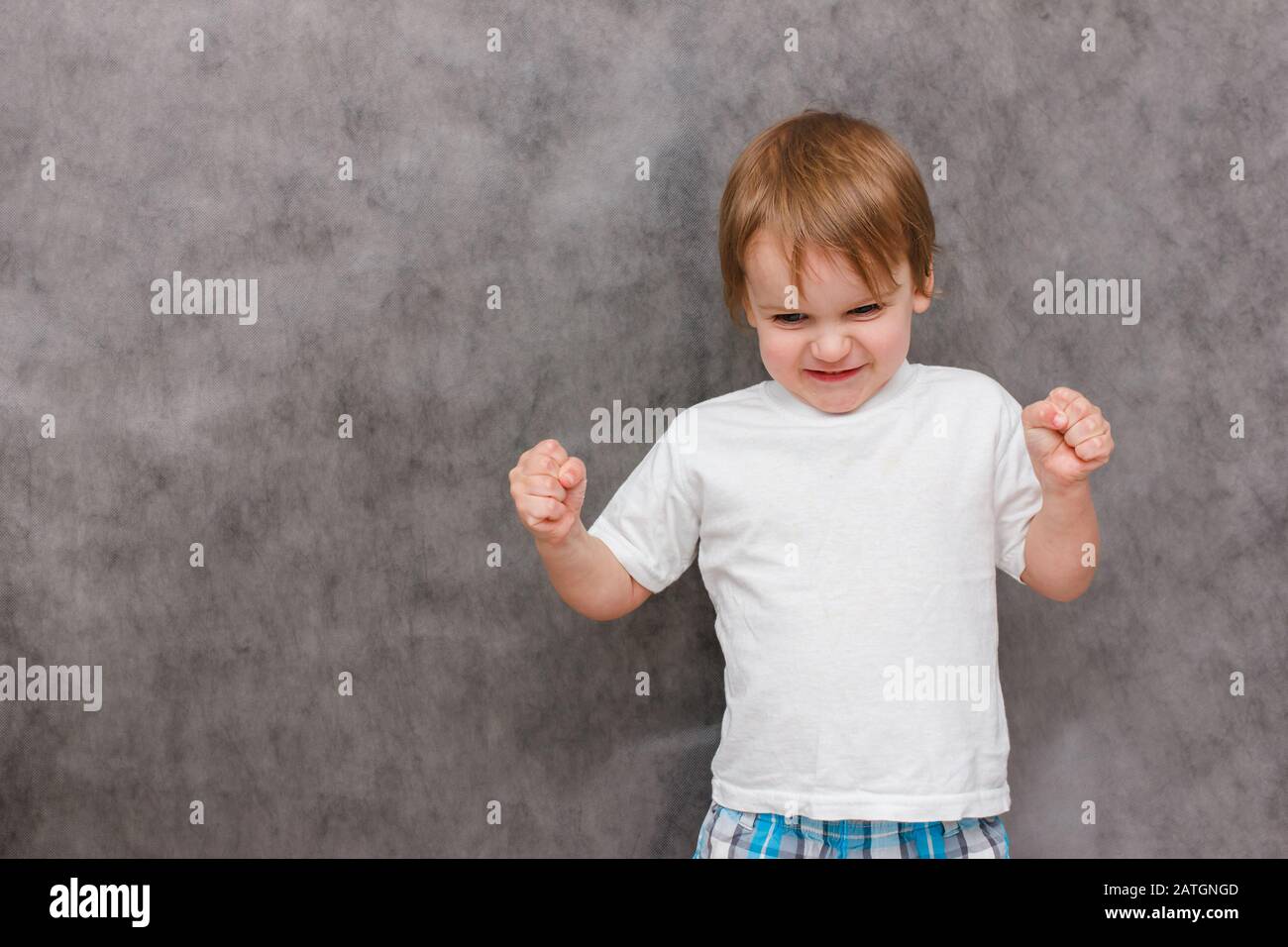 Angry boy is showing his arm muscles. Portrait of the boy of the ...