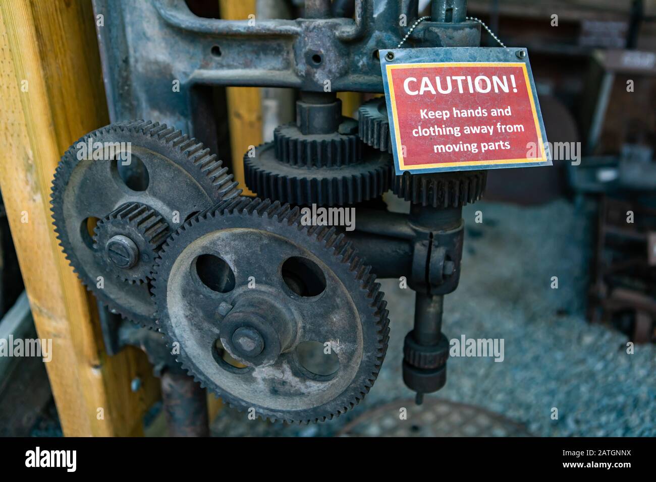 An antique industrial engine with a signboard - caution, keep hands and ...