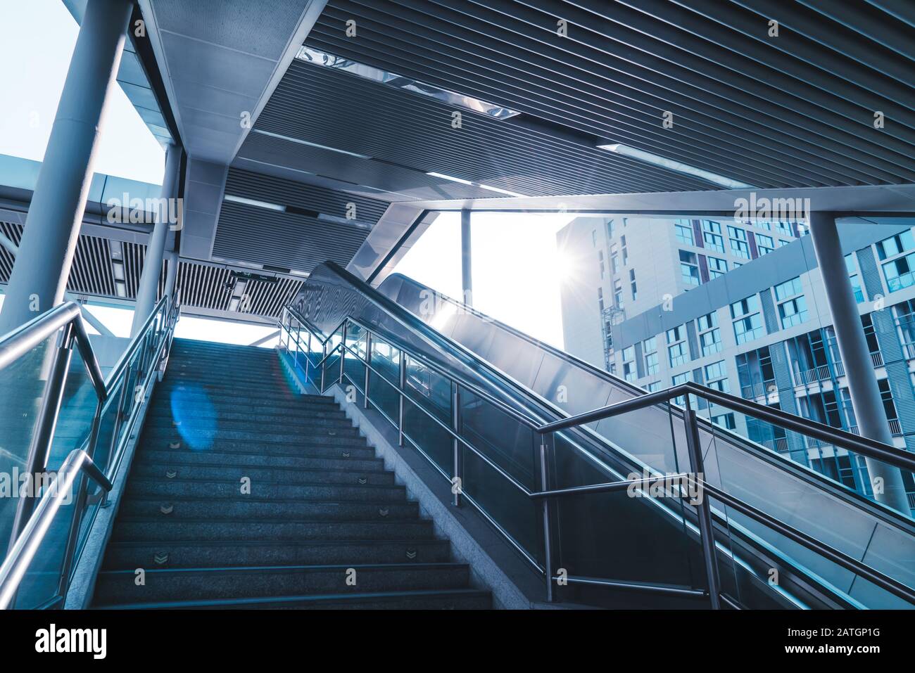 Outdoor elevators and city buildings, with sunlight in front. Urban ...
