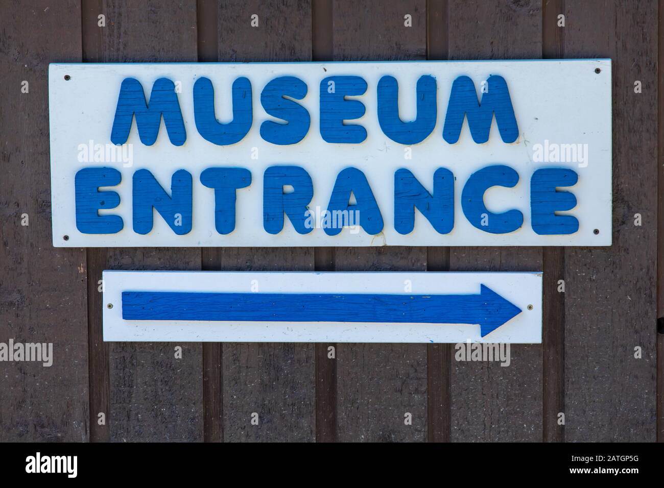 Museum entrance sign with direction showing to the right. Wooden sign ...