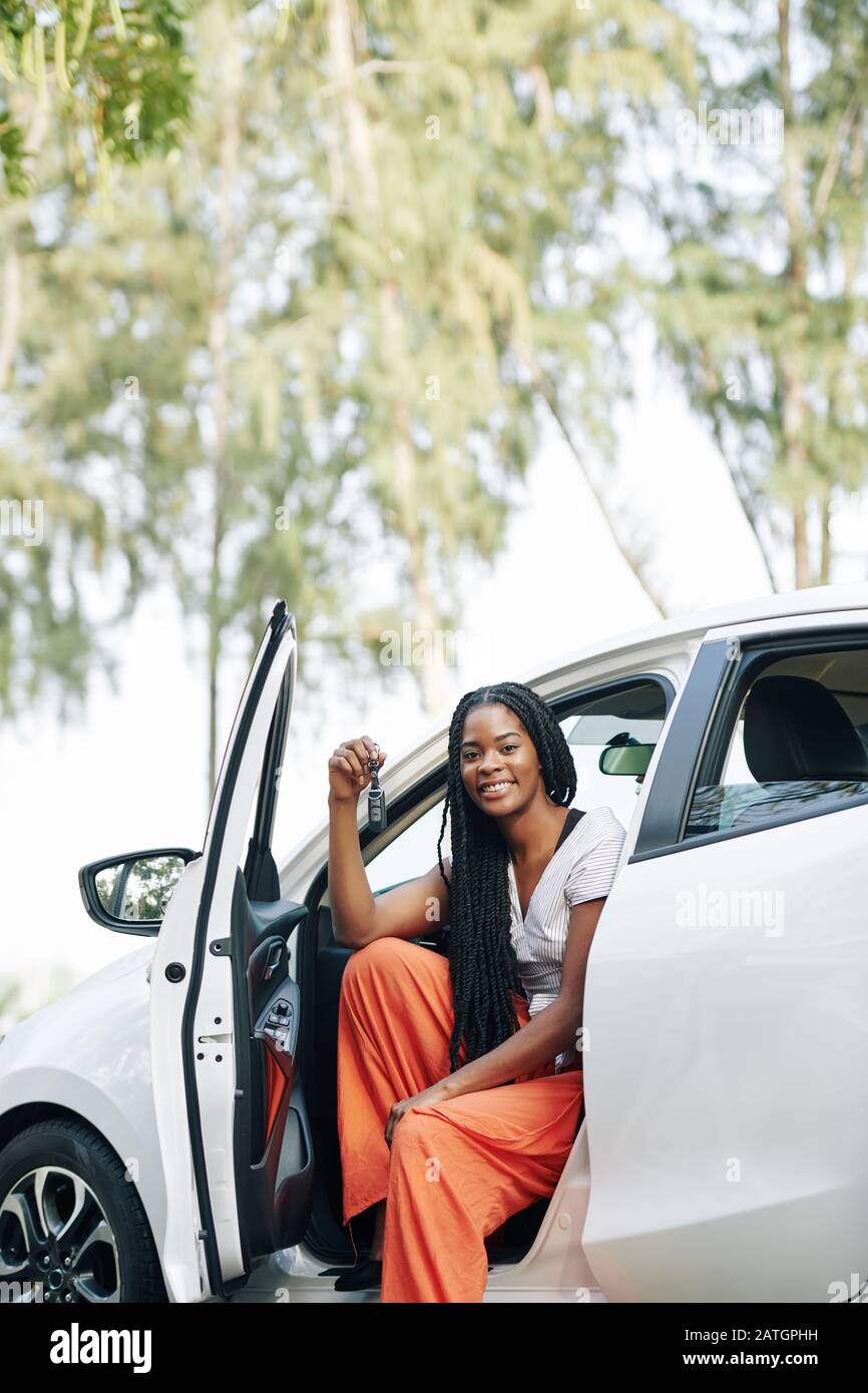 Happy pretty young Black woman sitting in her new car and showing keys ...