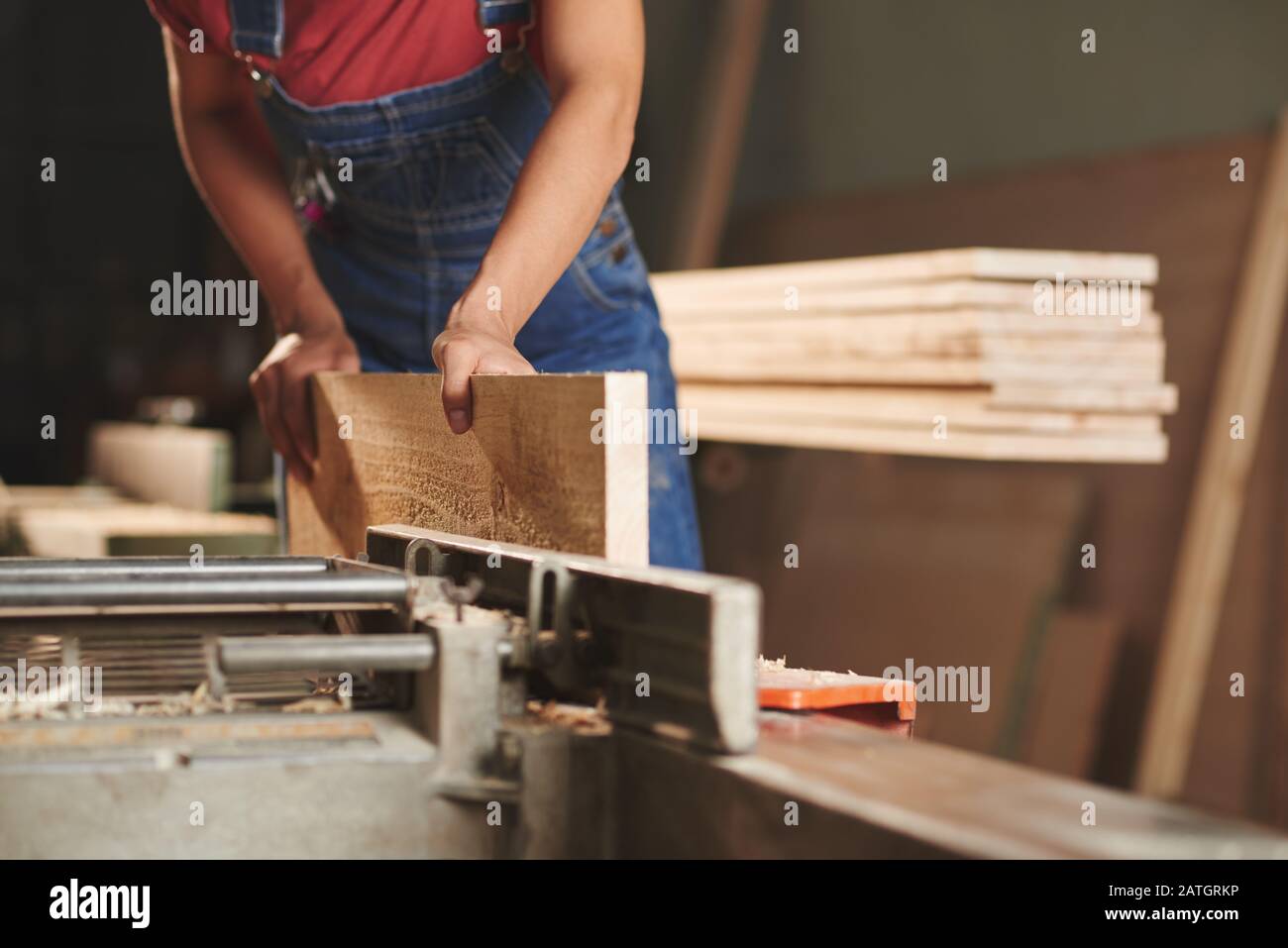 Close-up view of unrecognizable carpenter in denim overall processing ...
