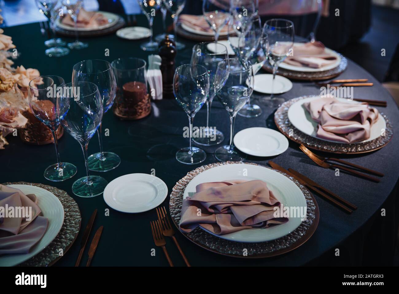 Glasses, forks, knives, plates on a table in restaurant served for ...