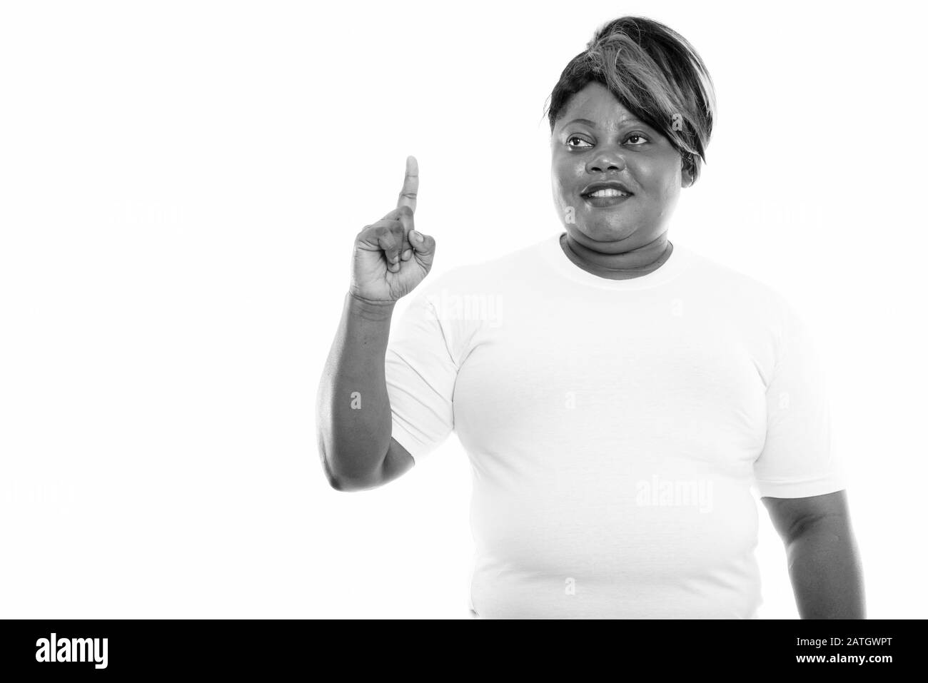 Happy overweight African woman pointing finger up while thinking ready ...