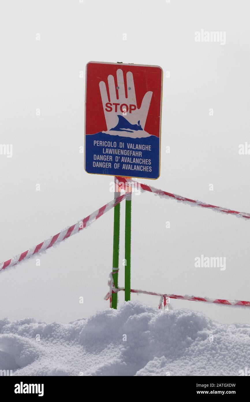 Danger sign – stop, avalanches. Off-piste sunlit snowy ski slope with ...