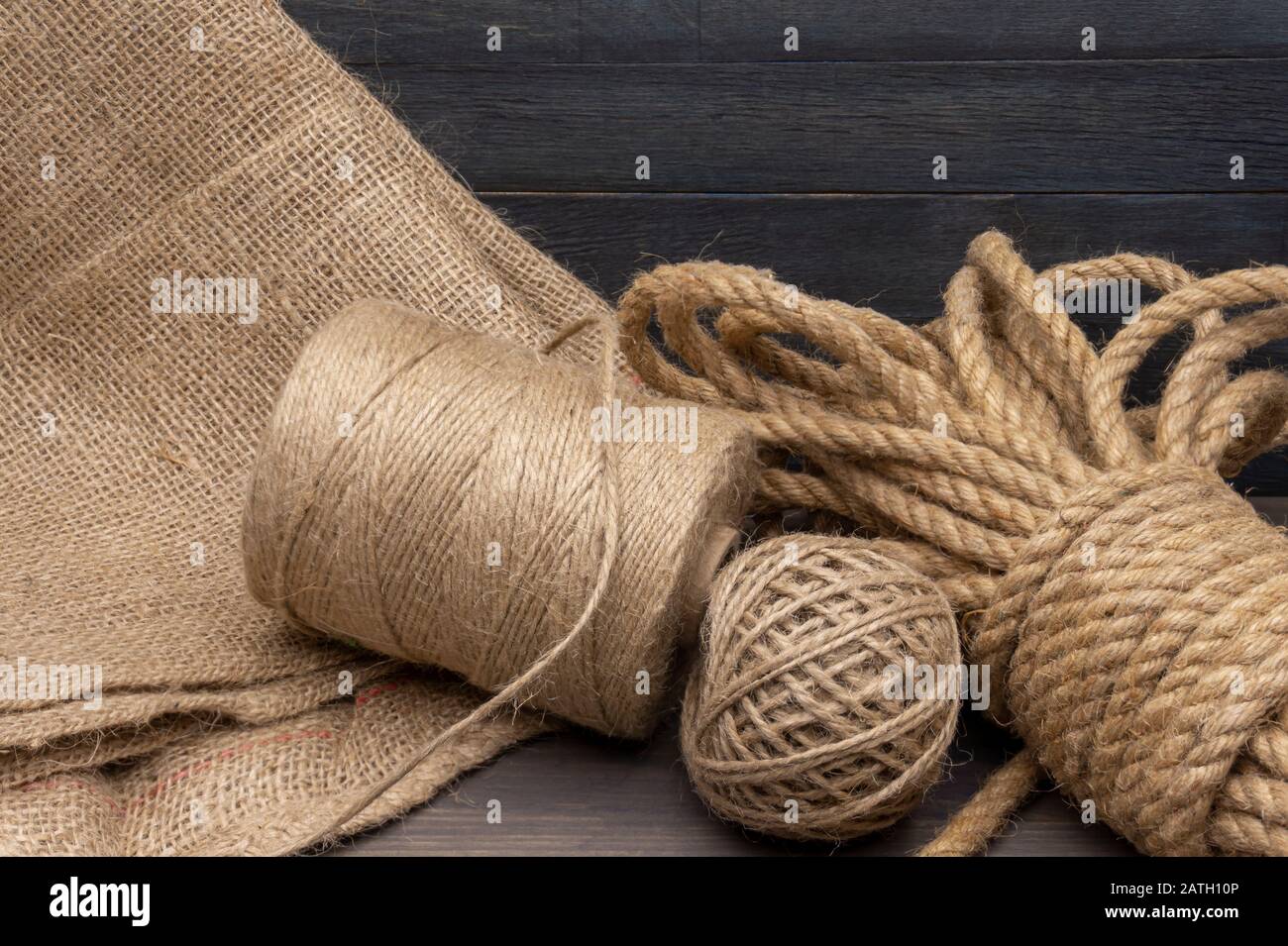 Jute rope and spools of burlap threads or jute twine in close-up on ...