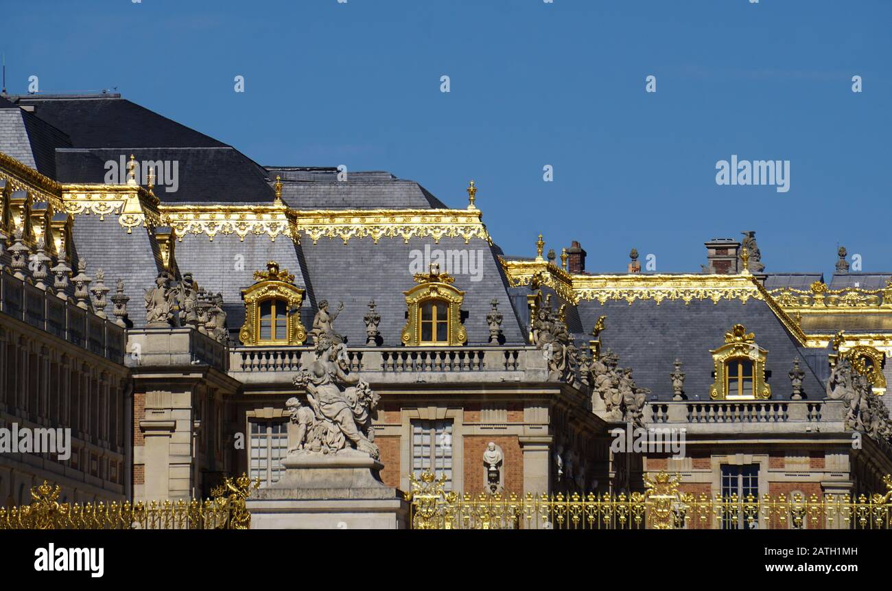 side view of the castle of Versailles, France with its gold rooftops ...