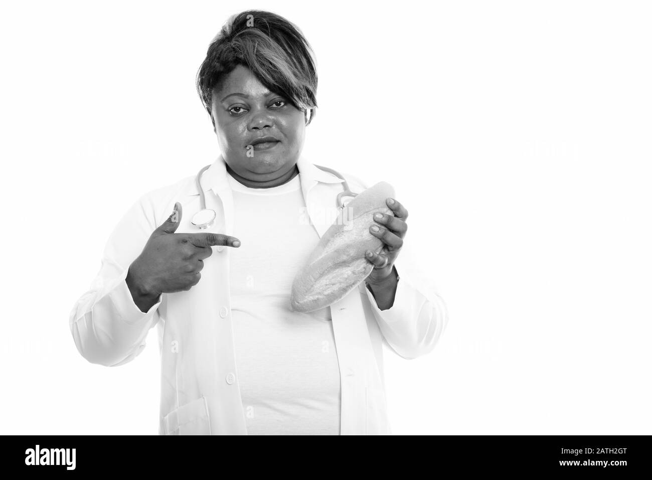 Studio shot of fat black African woman doctor holding and pointing at ...