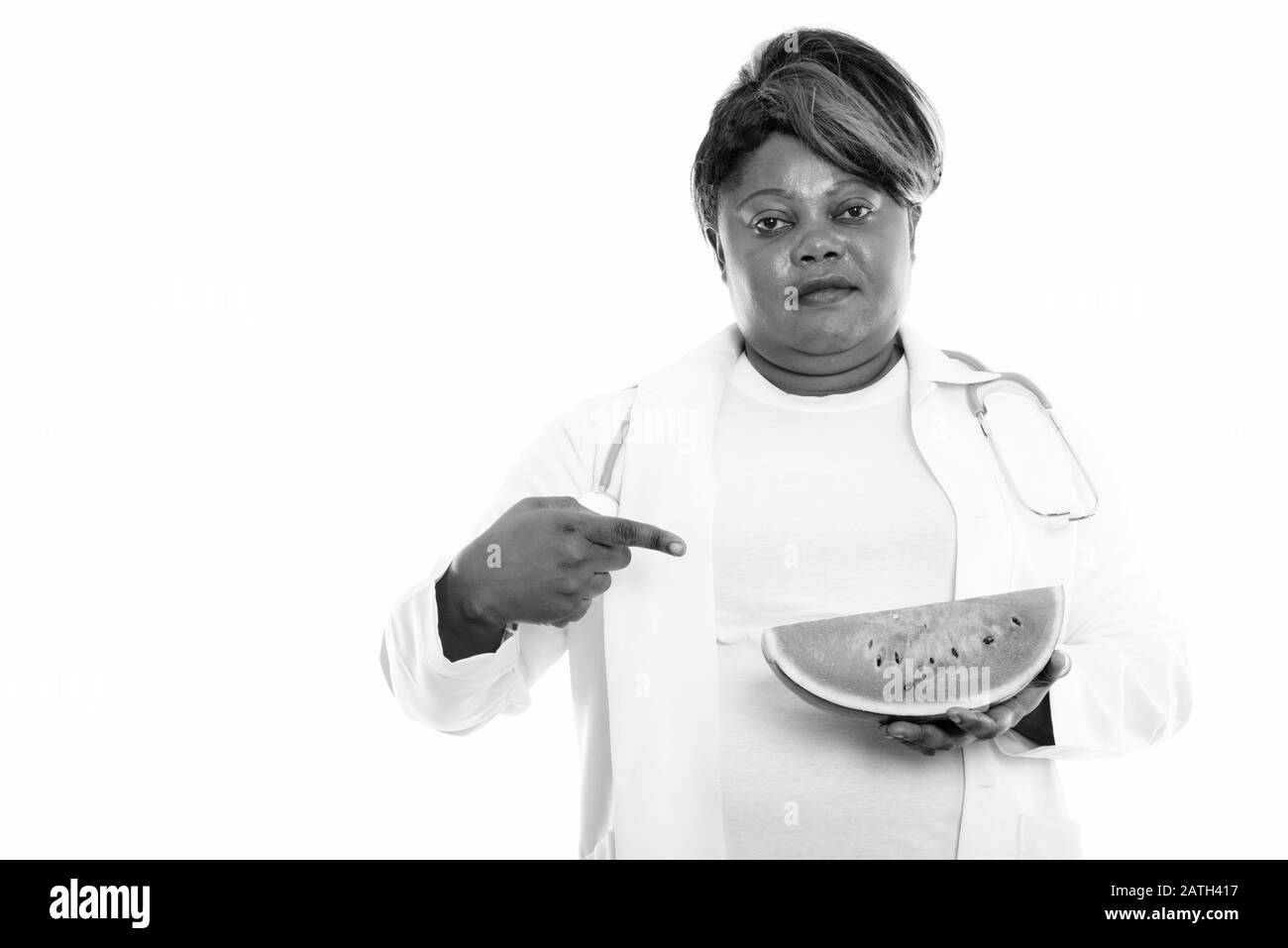 Studio shot of fat black African woman doctor holding and pointing at ...