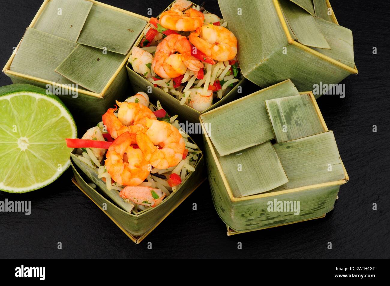 Steamed prawns and rice in bamboo leaf boxes on a slate stone ...
