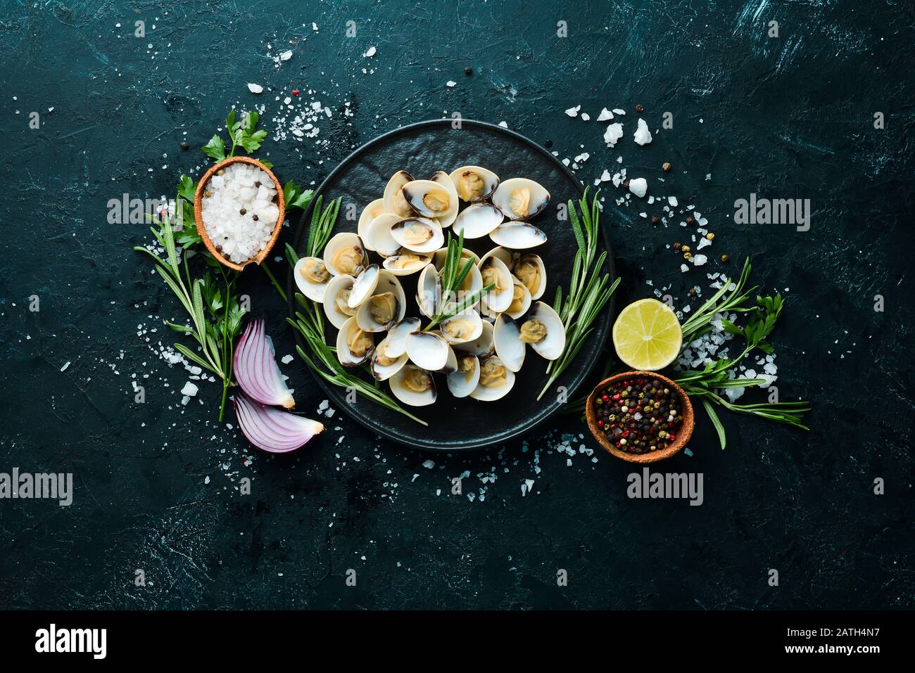 Boiled clams with spices in a plate. Seafood on black background. Top ...