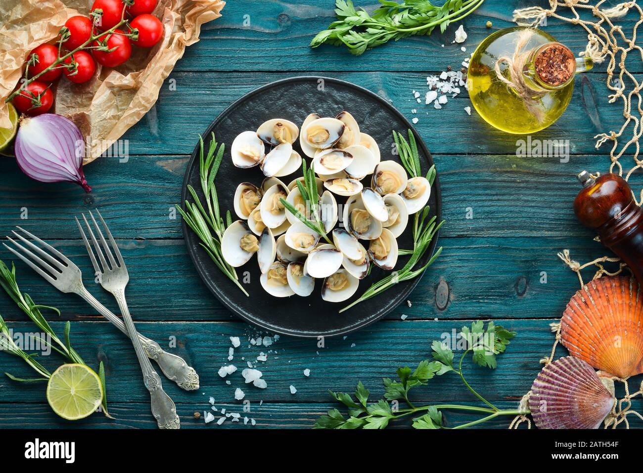 Boiled clams with spices in a plate. Seafood on black background. Top ...