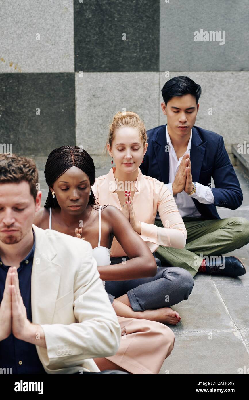 Group of concentrated business people closing eyes when meditating ...