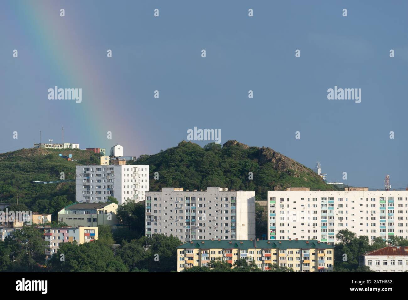 Urban landscape with a rainbow on the sky background. Vladivostok ...