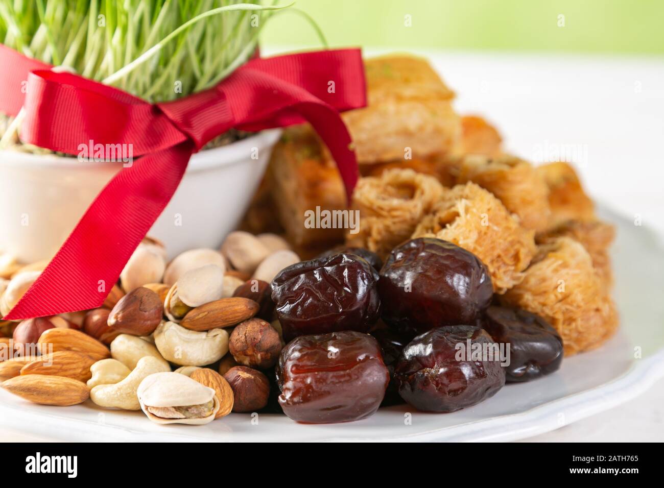 Nowruz holiday concept - grass, baklava sweets, nuts and seeds Stock ...