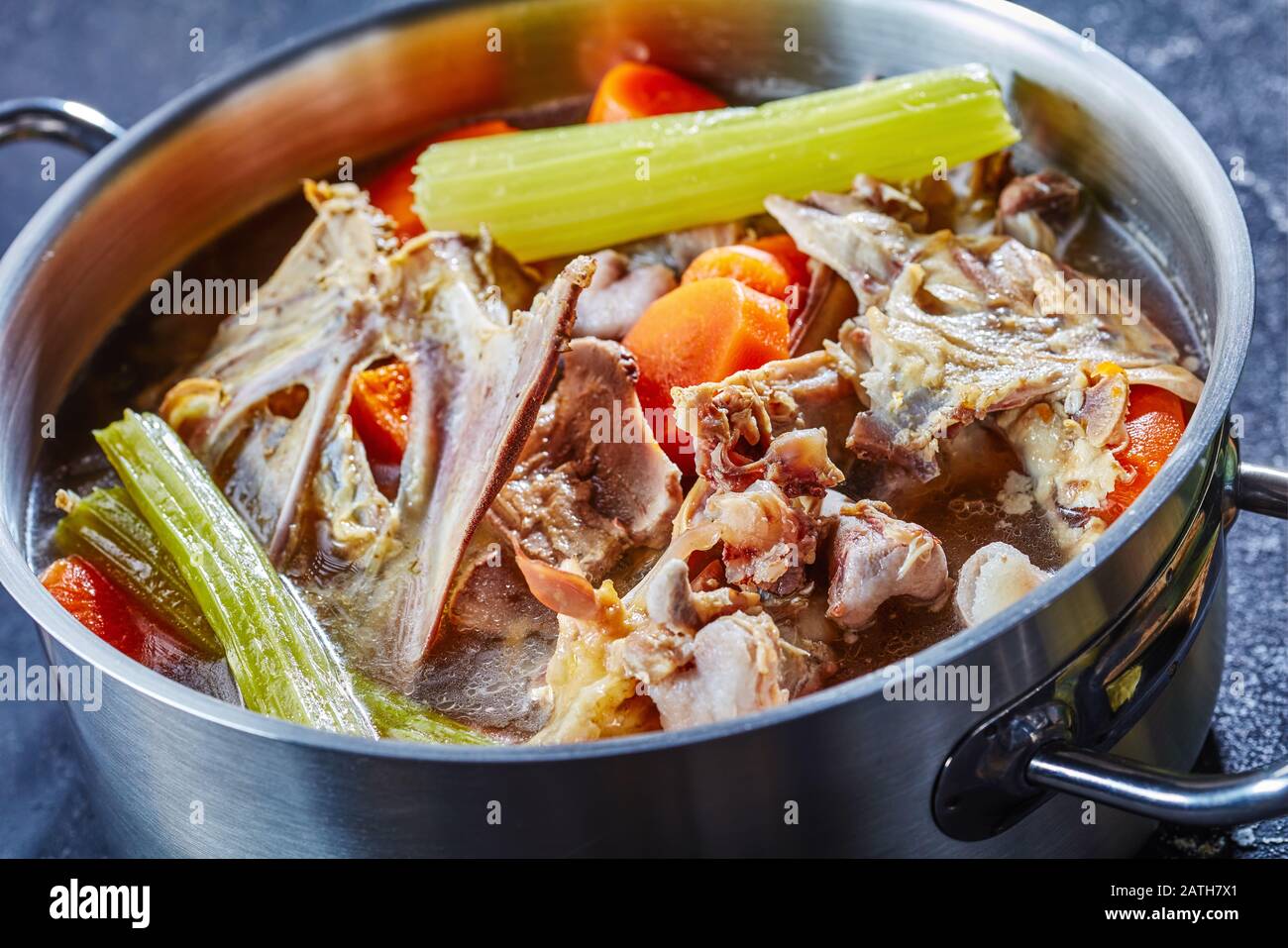 cooked chicken stock with vegetables and aromatic herbs in a stockpot ...