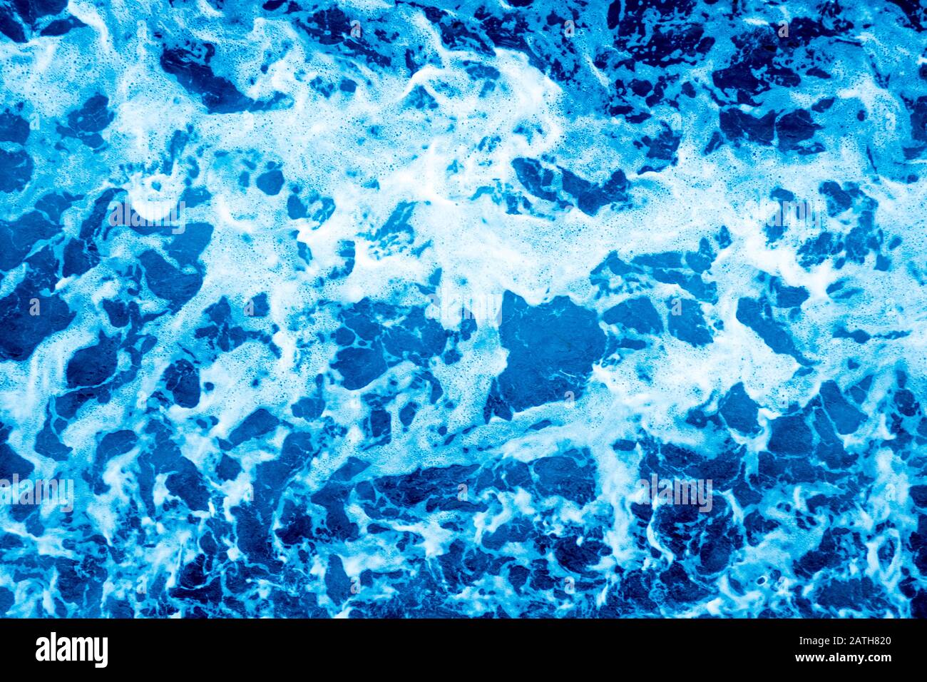 Aerial Ocean water surface with foam and waves behind of fast moving ...