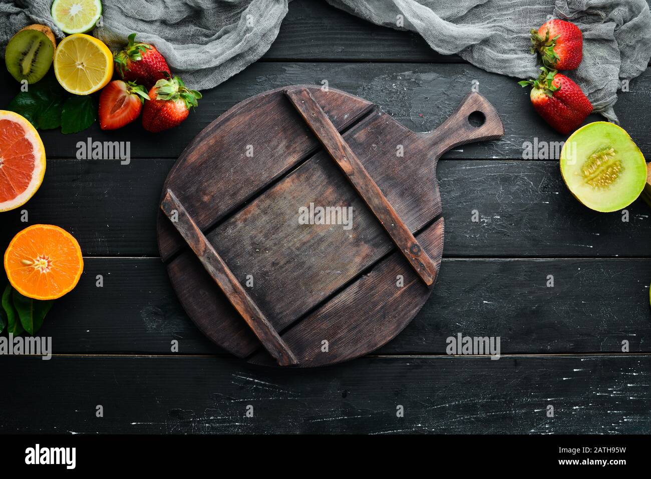 Fresh tropical fruits on a black background. Citrus, melon, pomegranate ...