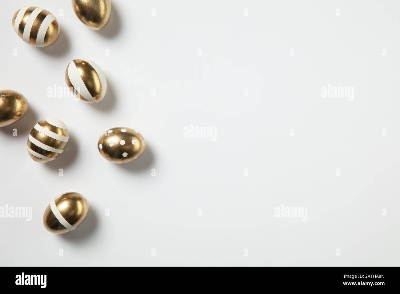 Egg hunt is coming. Easter traditions, golden colored eggs on white ...