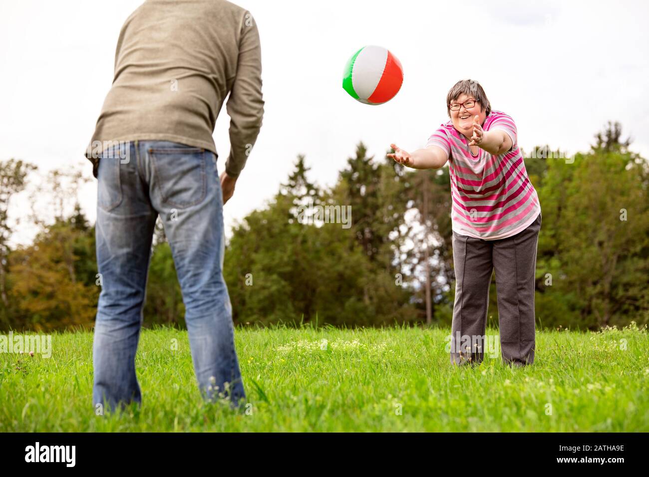 mental disabled woman is throwing a ball to a man to train her motor ...