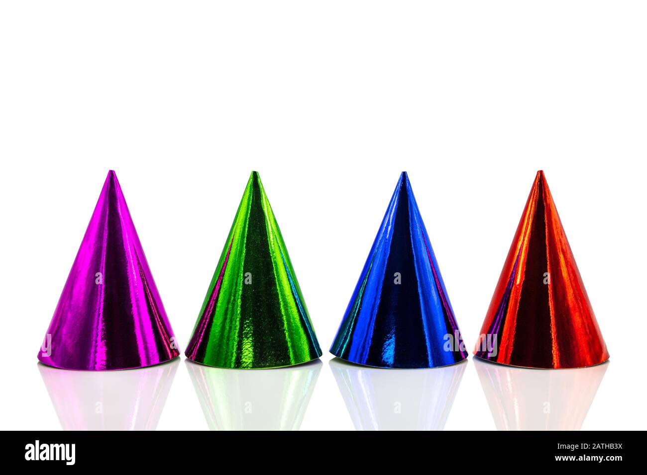 Four colorful party hats with reflections, isolated on white background ...