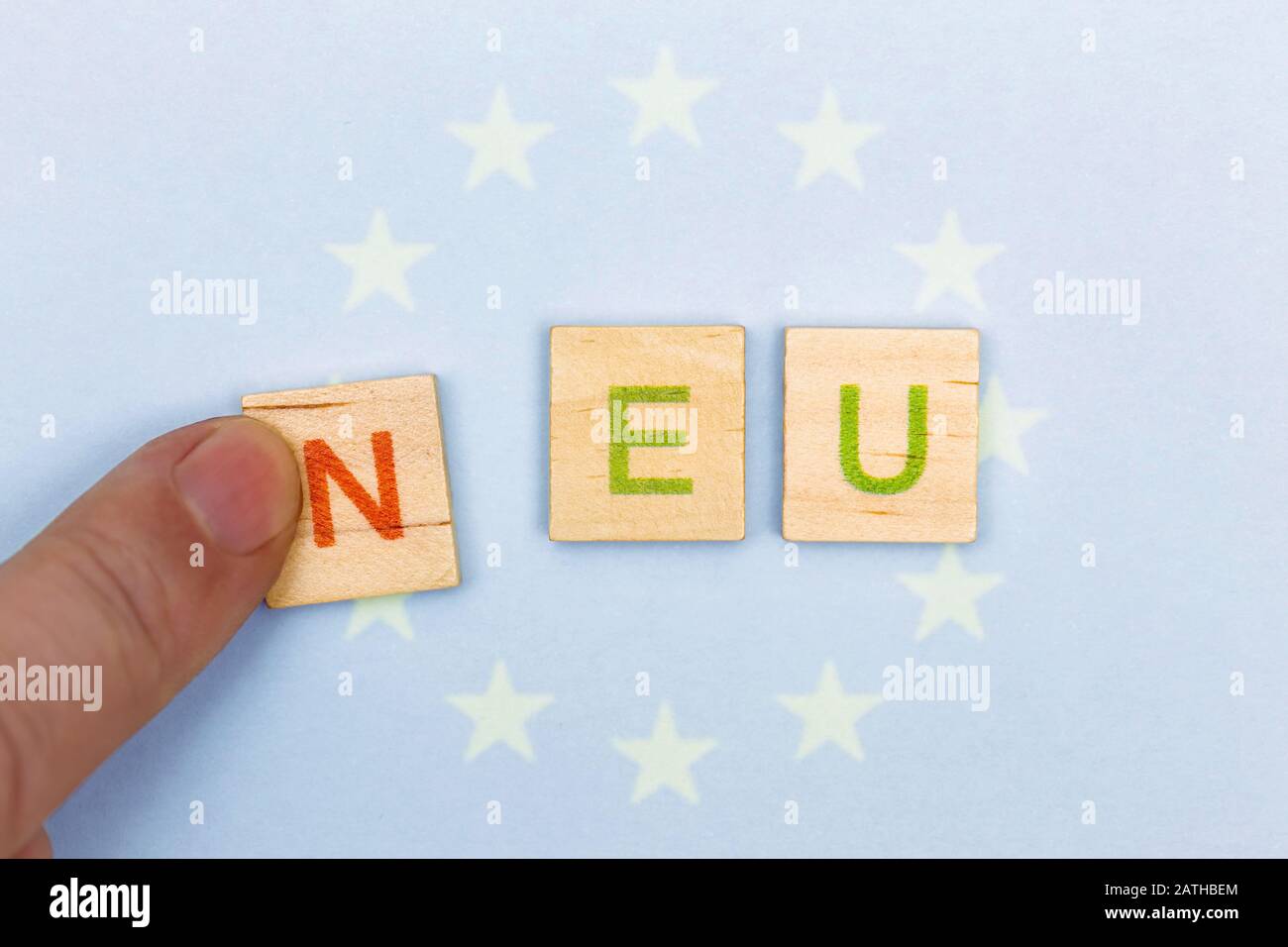 Top view of a finger sliding the letter N on the letters EU, concept ...
