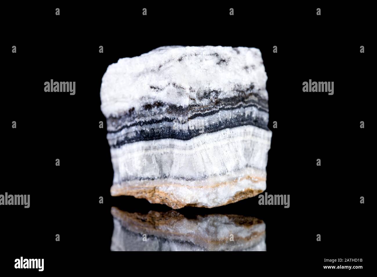 Raw white calcite mineral stone in front of black background ...