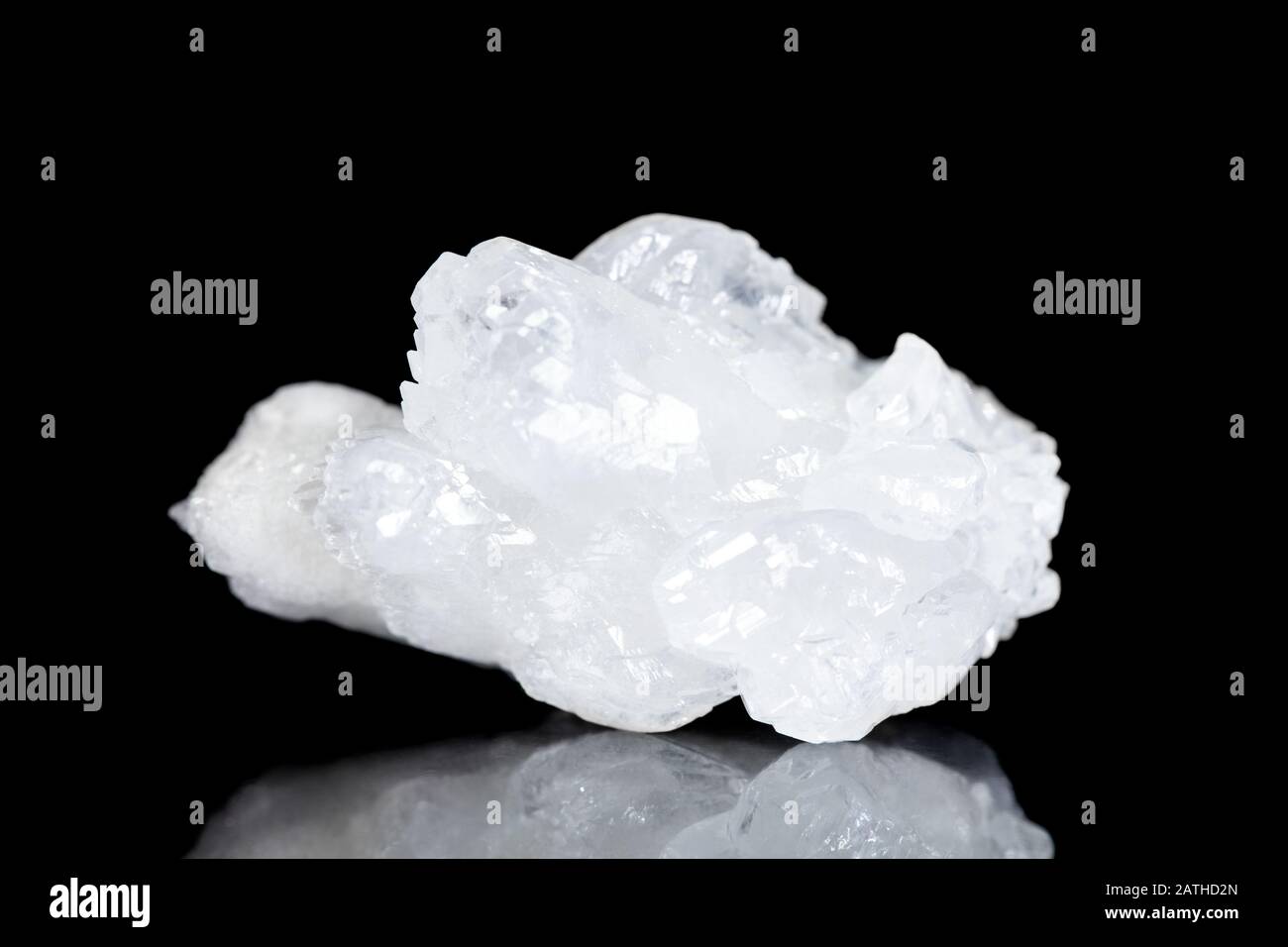 Raw white quartz mineral stone in front of black background, mineralogy ...
