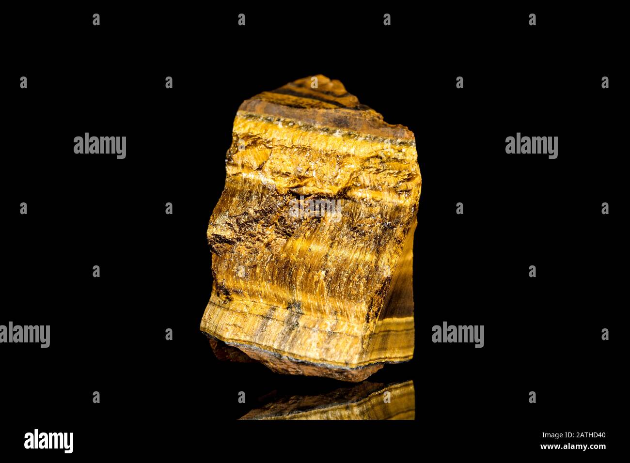 Raw tiger eye mineral stone in front of black background, mineralogy ...
