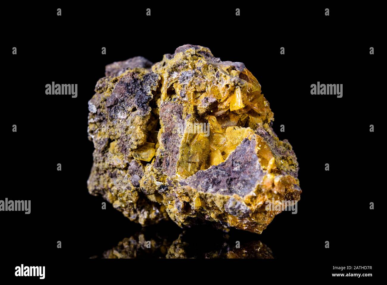 Raw wulfenite mineral stone on mother rock in front of black background ...