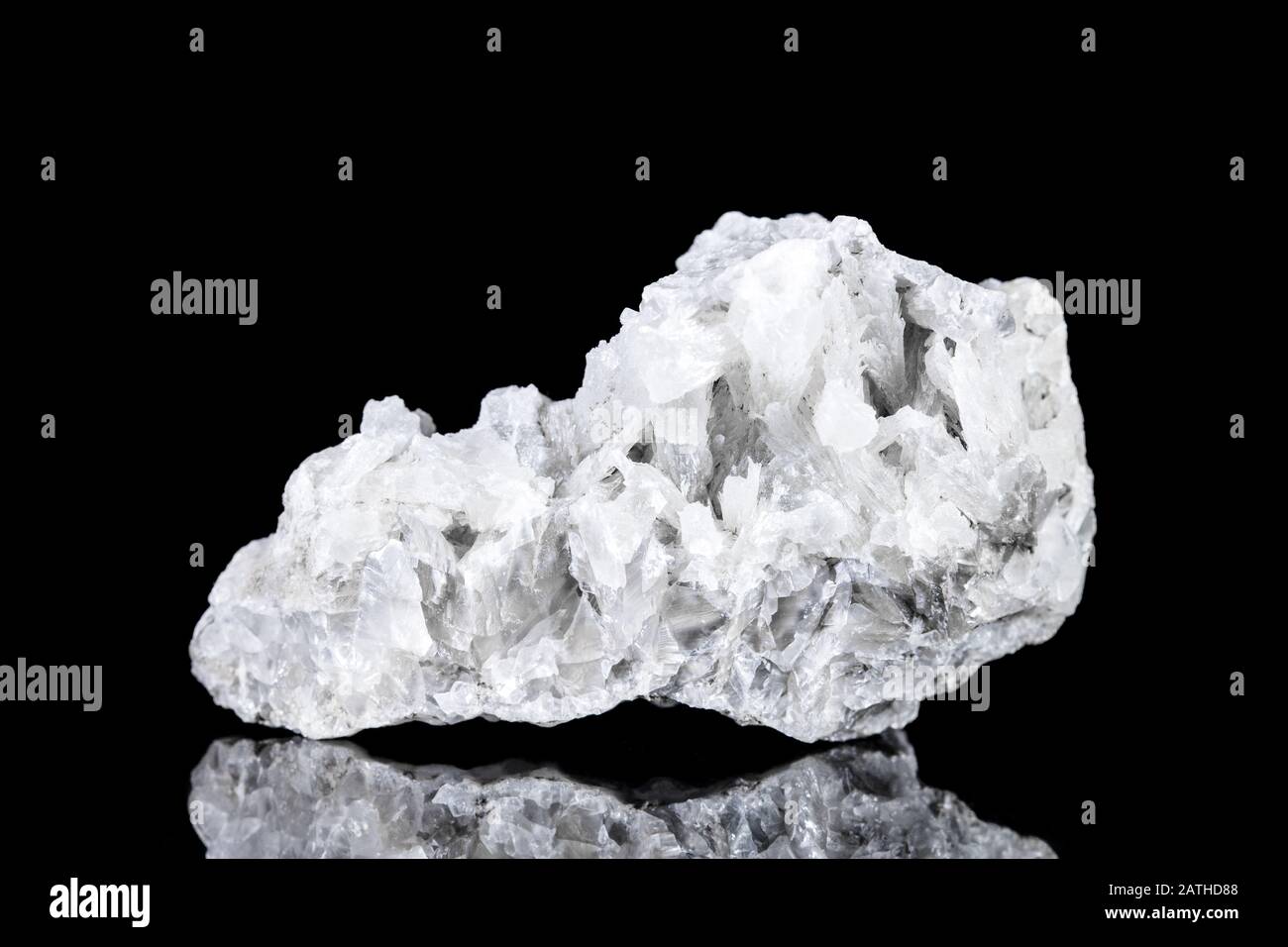 Raw white calcite mineral stone in front of black background ...