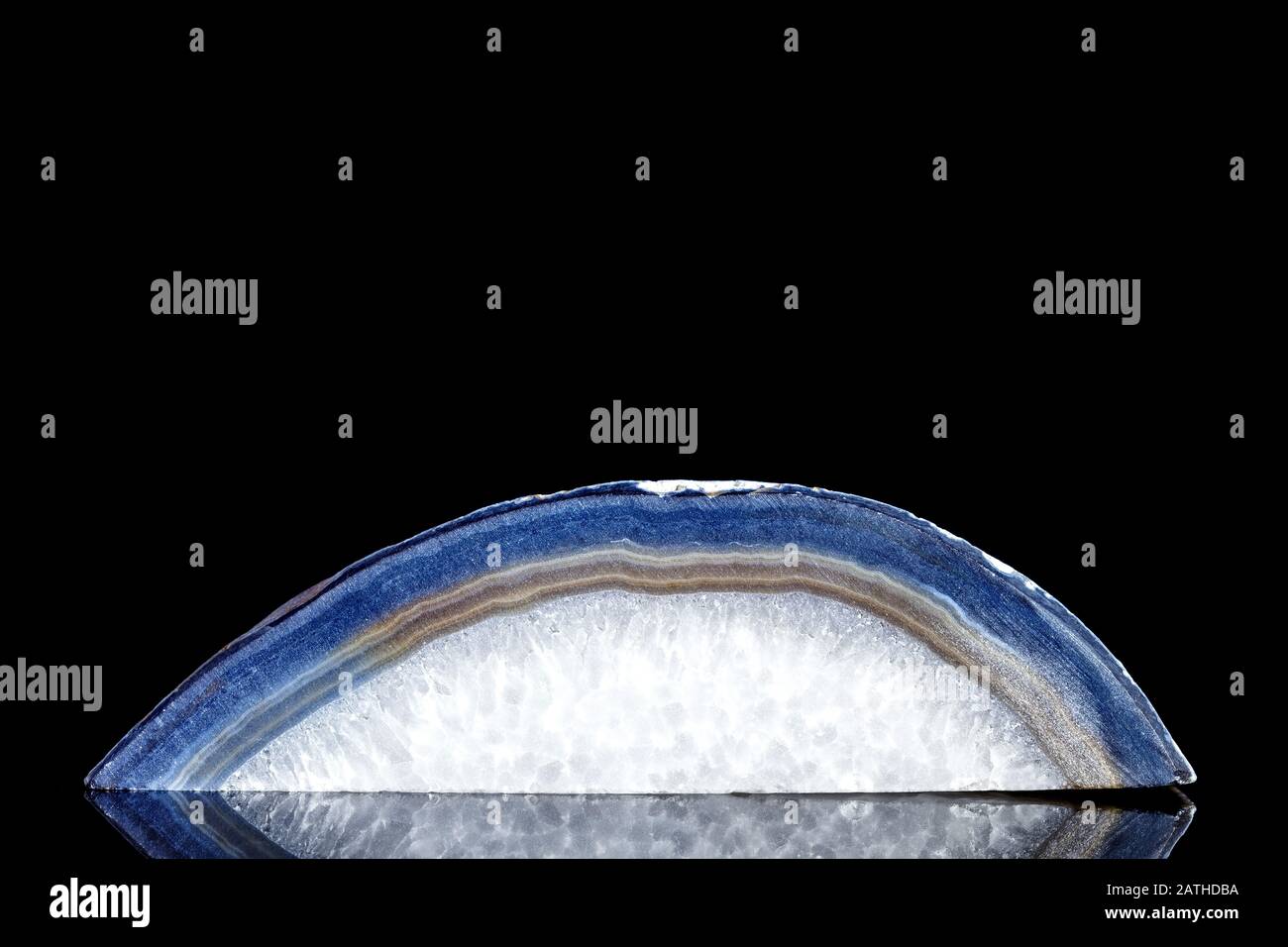 Raw bi-color agate mineral stone in front of black background ...