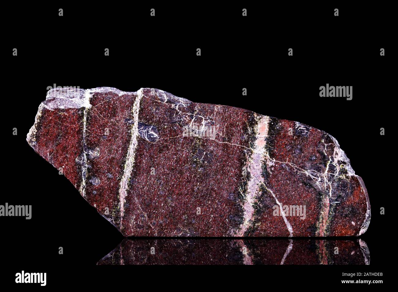 Raw red jasper mineral stone in front of black background, mineralogy ...