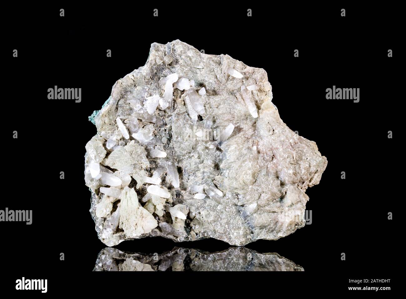 Raw white quartz mineral stone on matrix in front of black background ...