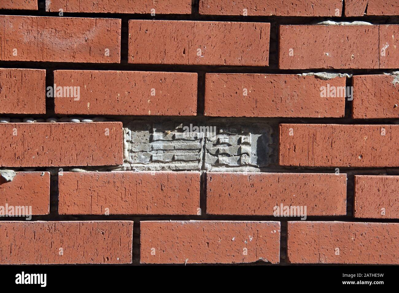 Garden wall with missing a brick Stock Photo - Alamy