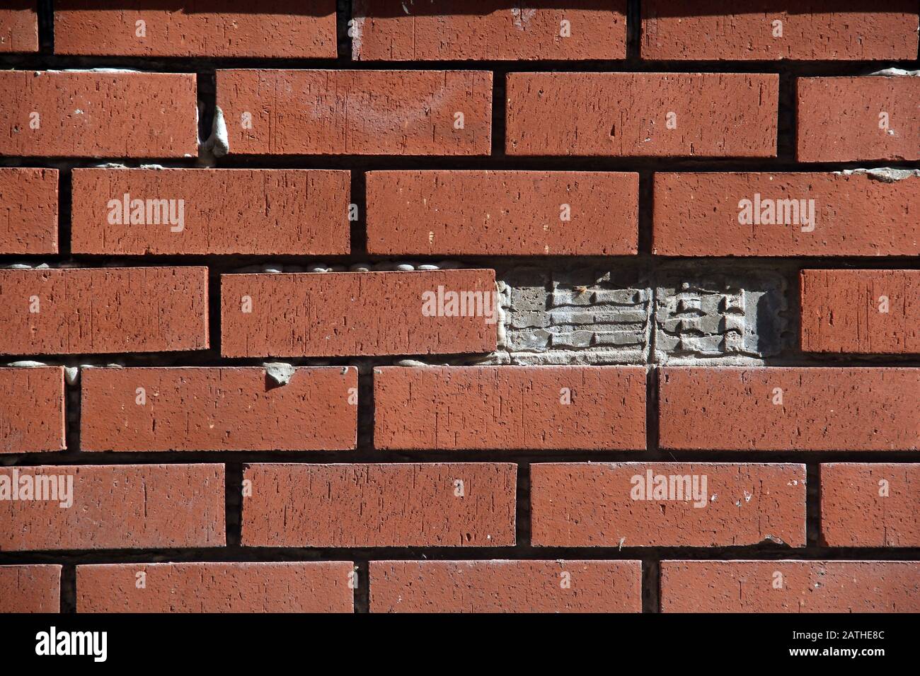 Garden wall with missing a brick Stock Photo - Alamy