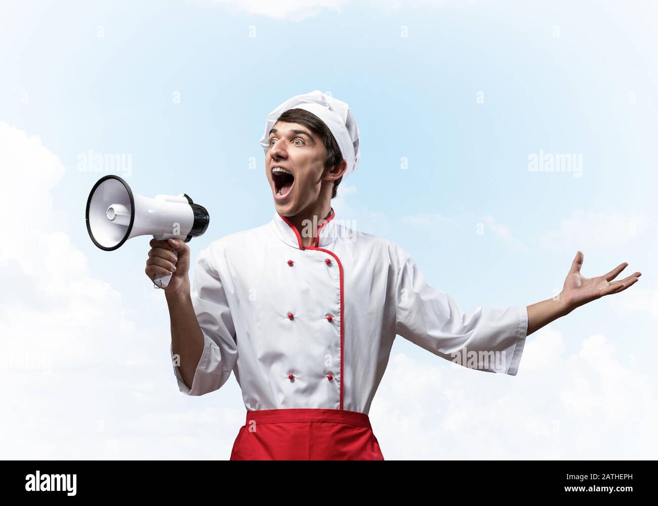 Young chef shouting loudly into megaphone Stock Photo - Alamy