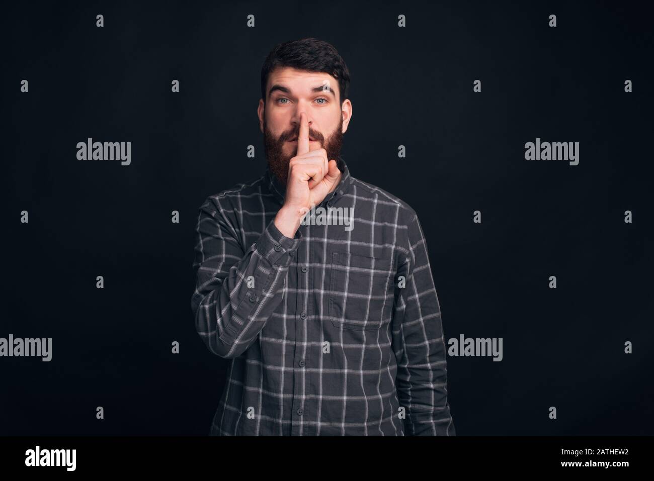 Portrait businessman showing silence gesture hi-res stock photography ...