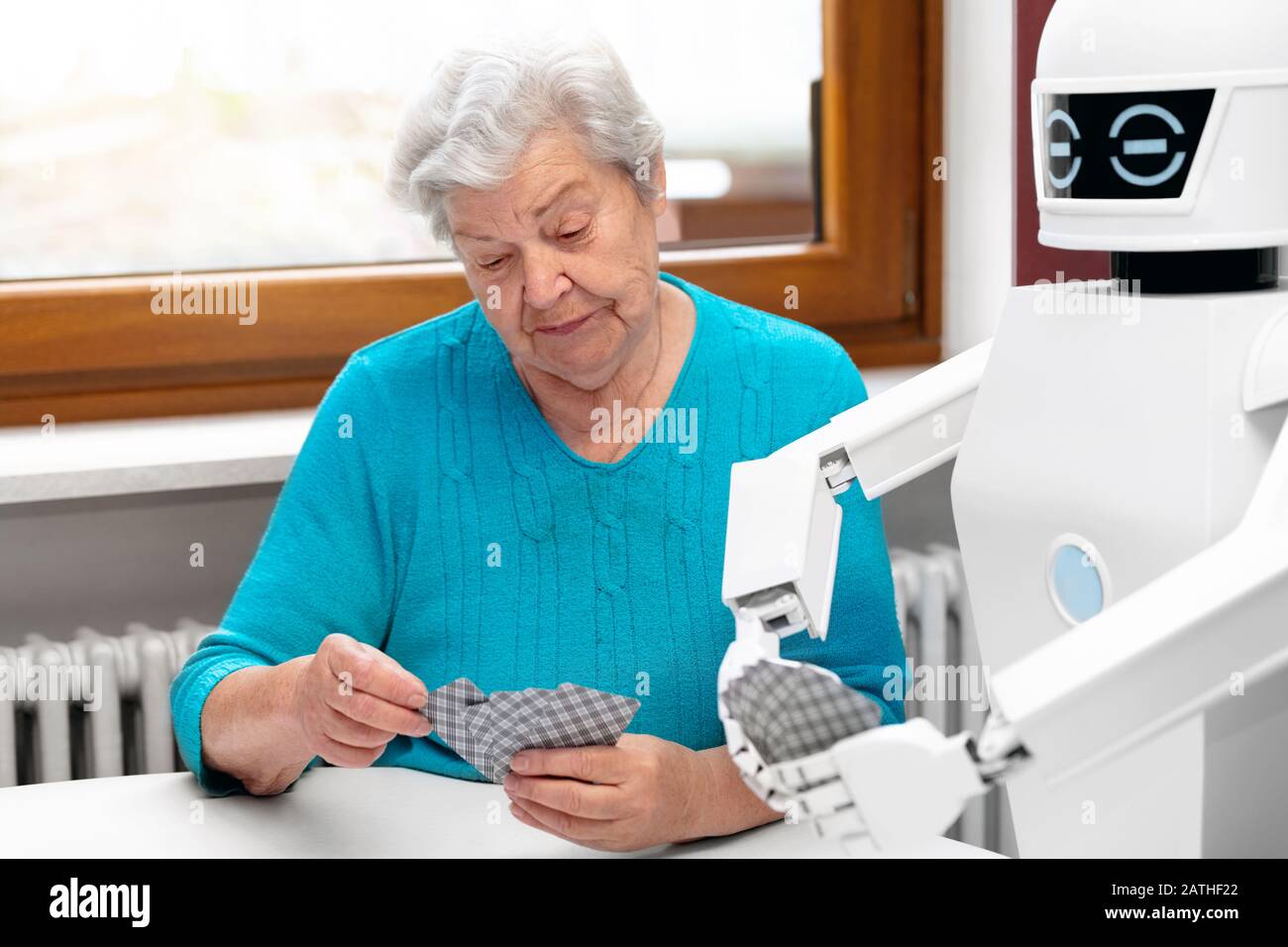 ambient assisted living service robot is playing a card game with a ...