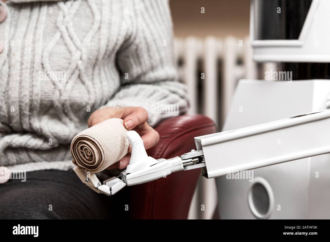 autonomous caregiver robot is holding a elastic bandage, giving it to ...
