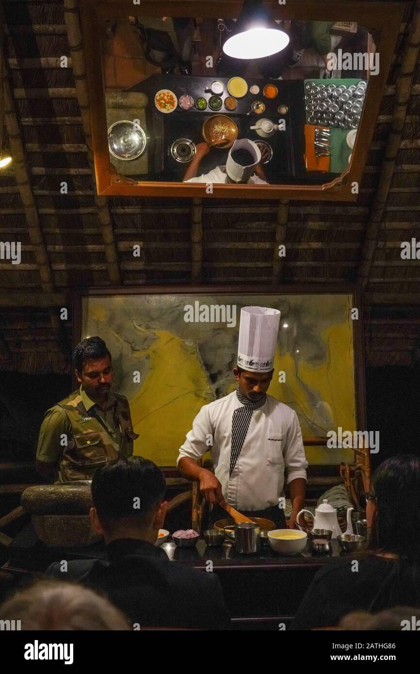 An Indian chef giving a cooking demonstration. From a series of travel ...