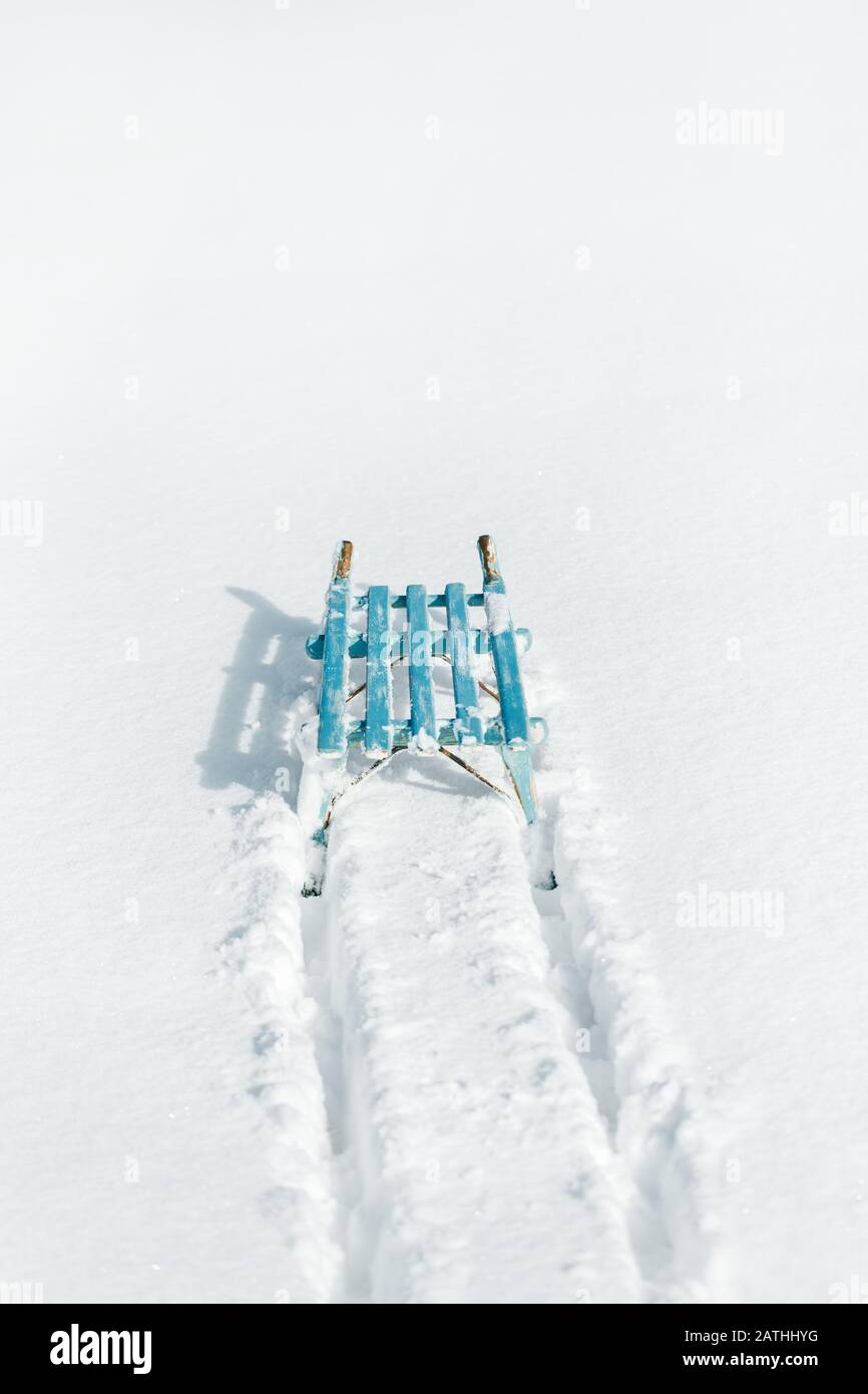 Blue Sledge or sleigh with sledging tracks on the deep snow, copyspace ...