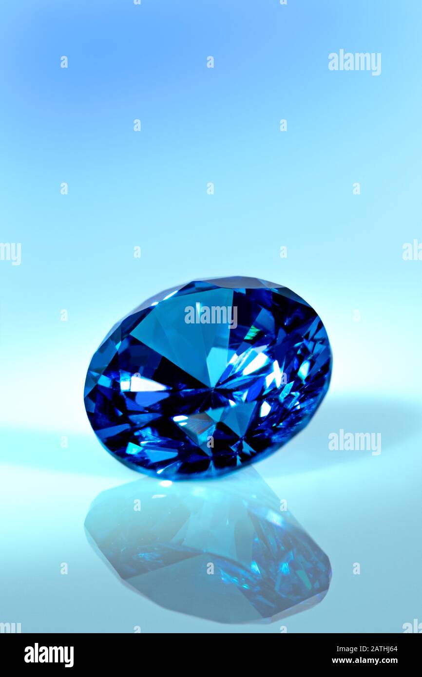Blue diamond or sapphire in front of blue background, brilliant cut ...
