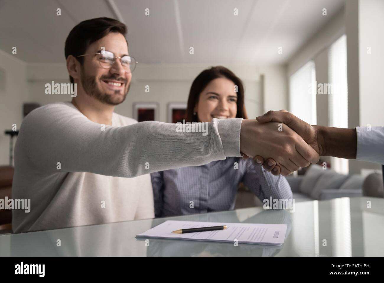 Smiling satisfied millennial man shake hands with insurance agent Stock ...