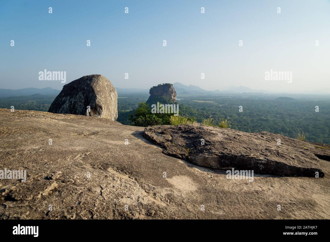 Big Stone on sunny orange Pidurangala Rock with view on Lions Rock with ...