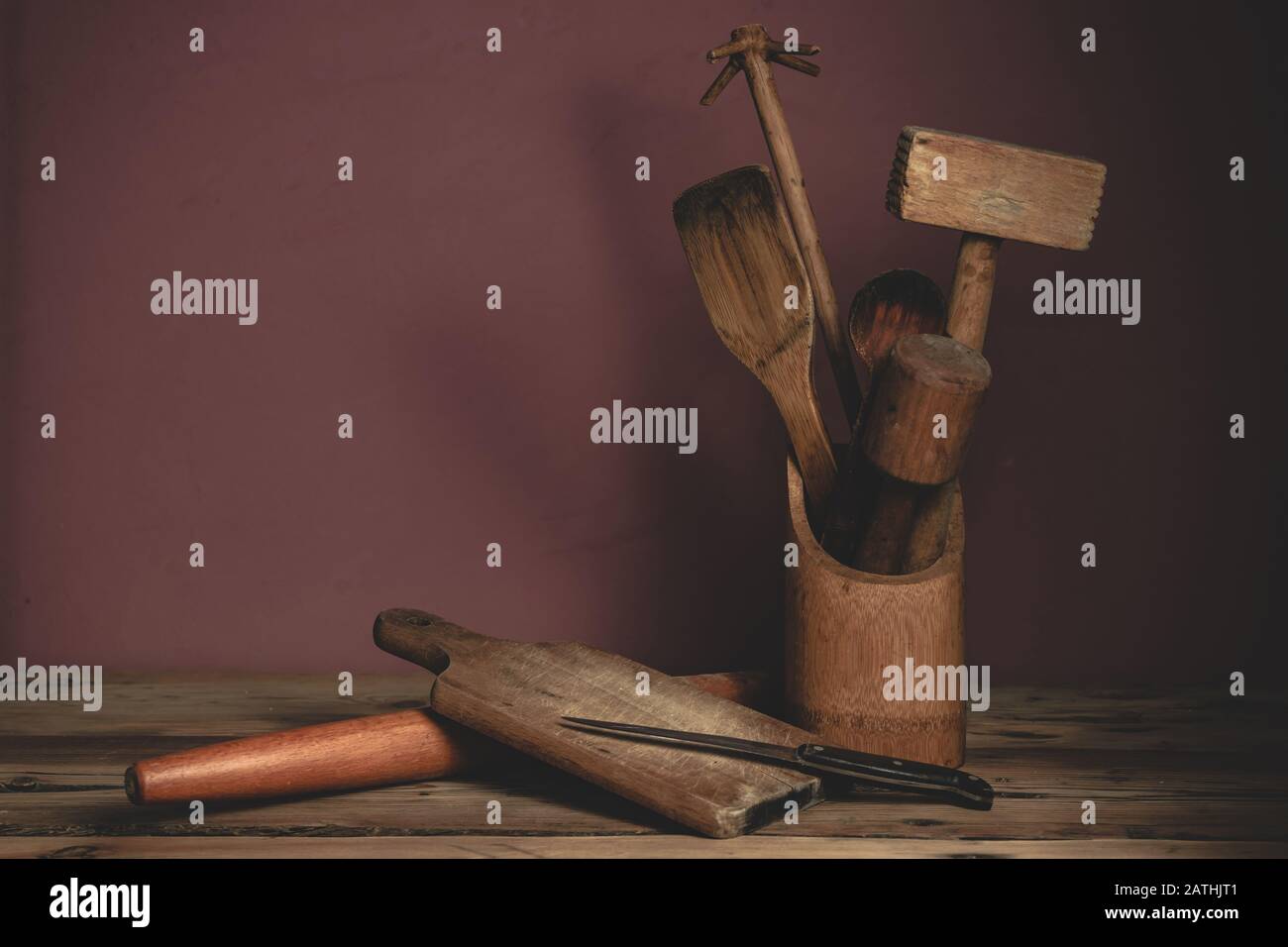 Beautiful vintage kitchen utensils on a oak wooden table and red wall ...