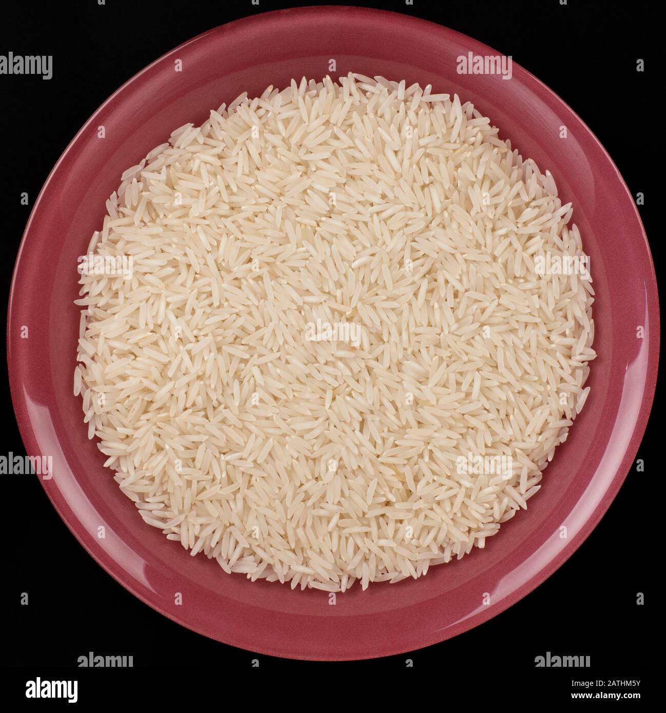 Large quantity of dry uncooked basmati rice lying in round purple ...